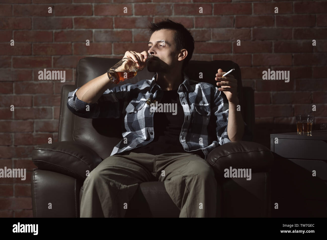 Man drinking whiskey and smoking cigarette in armchair. Alcoholism ...
