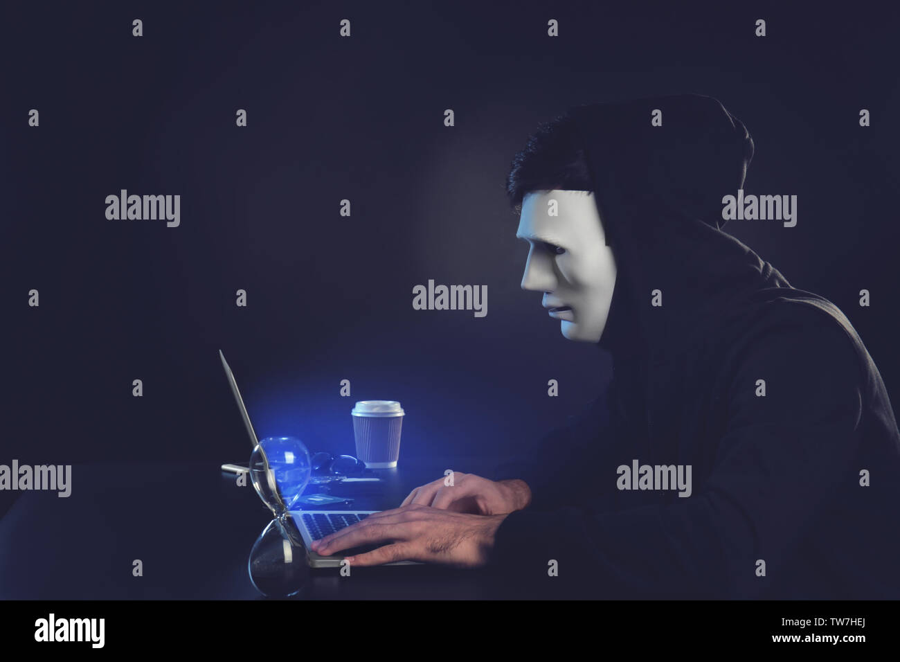 Masked man hacking server in darkness Stock Photo - Alamy
