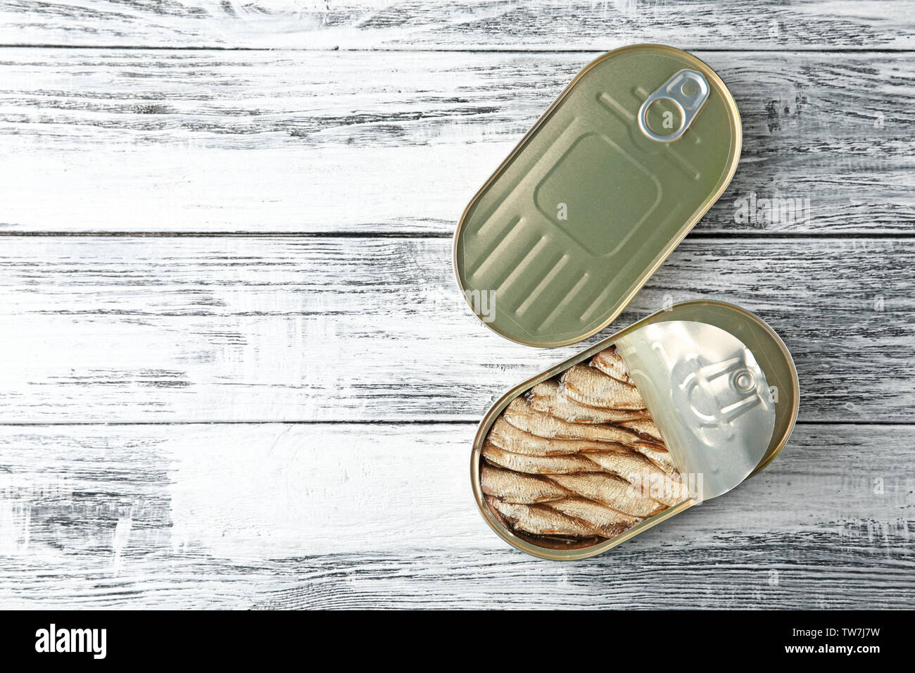 Open and closed tin cans with fish on wooden background Stock Photo - Alamy