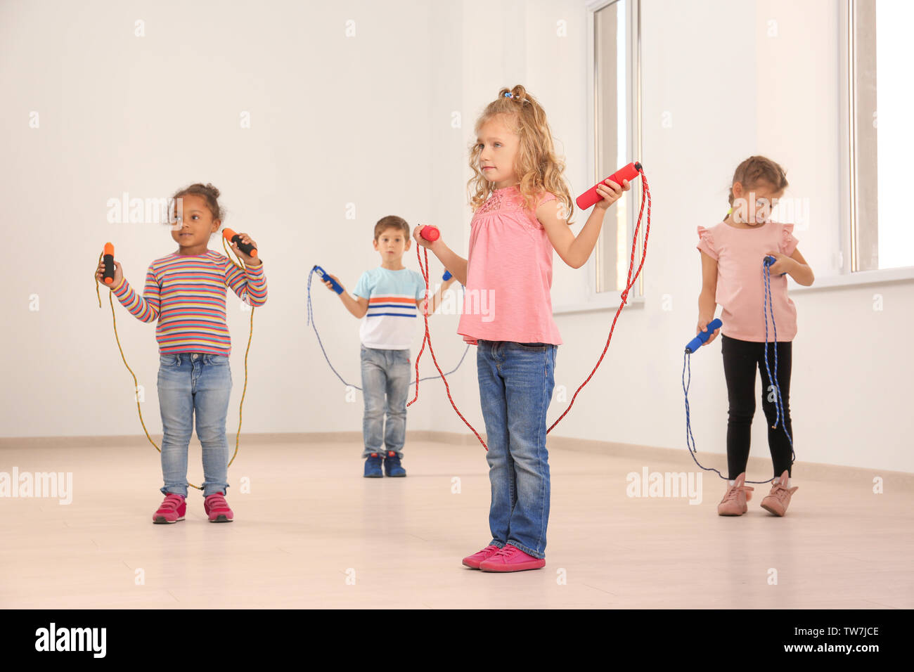 Cute children skipping rope in light room Stock Photo - Alamy