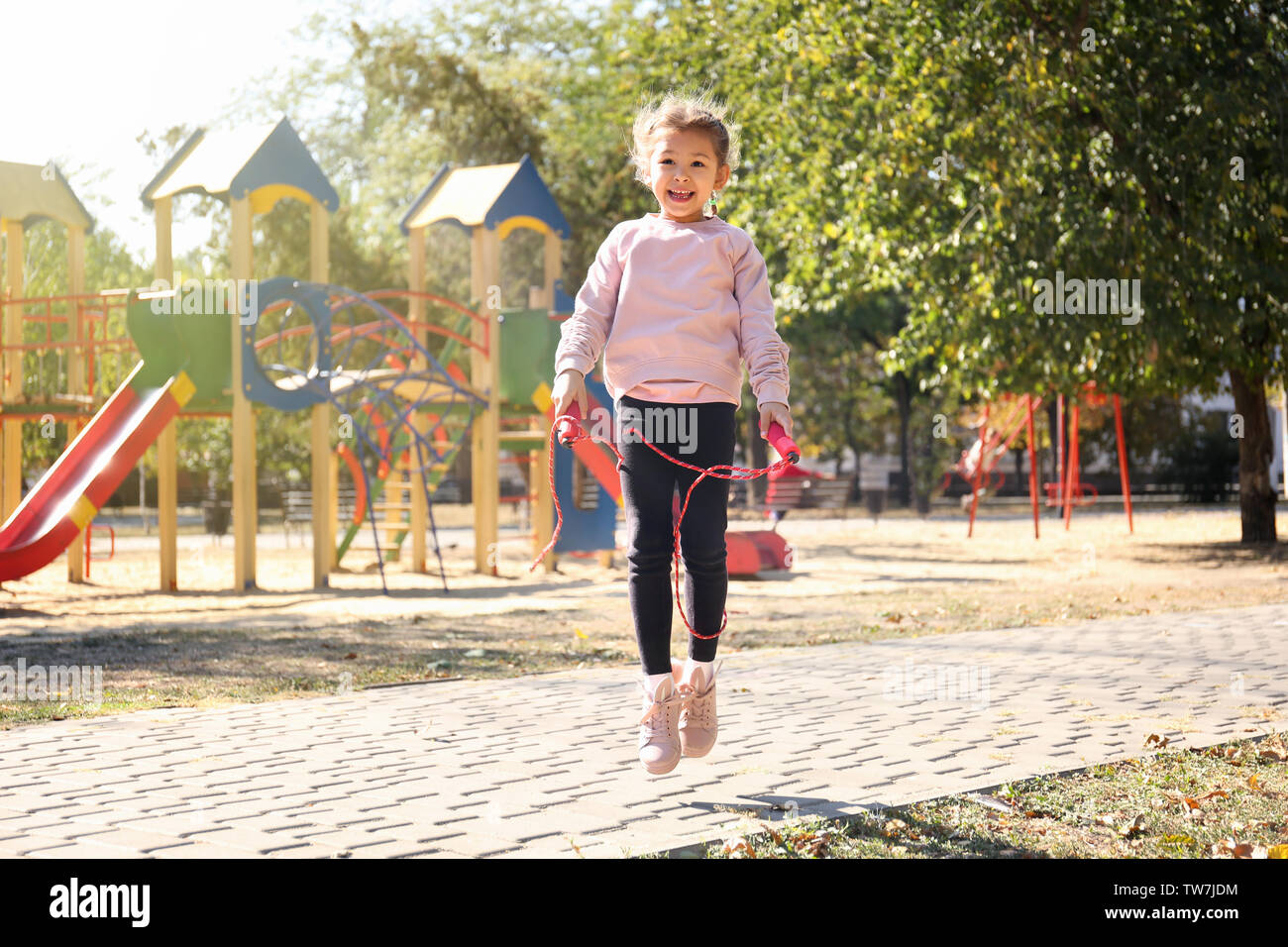 Cute girl skipping rope, outdoors Stock Photo - Alamy