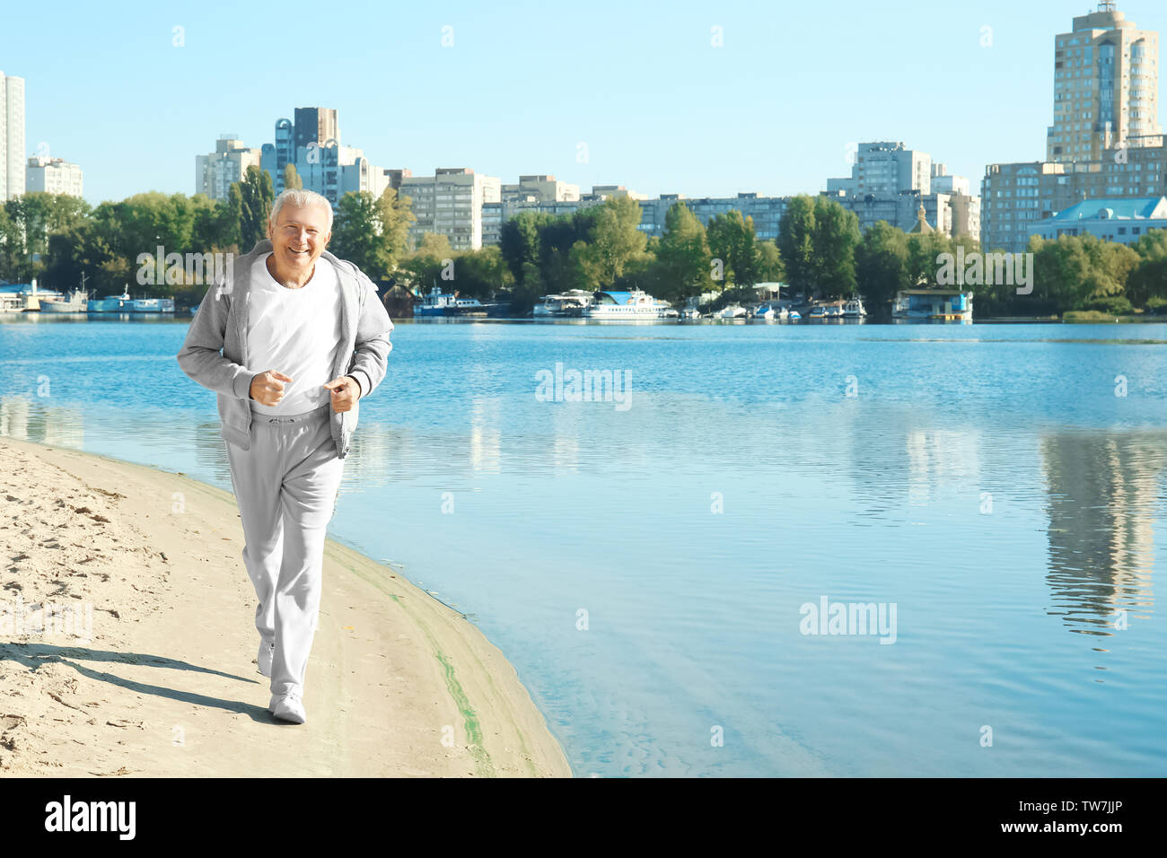 Mature man running near river Stock Photo - Alamy