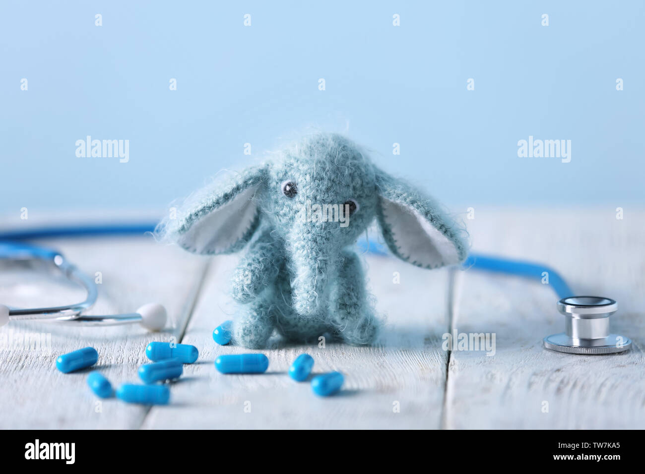Toy elephant, pills and stethoscope on table. Pediatrician concept ...