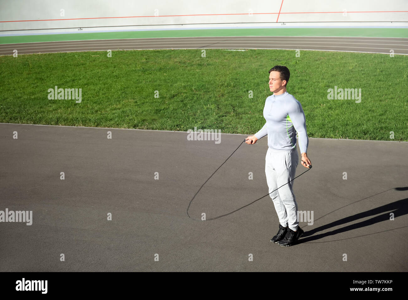 Sporty young man jumping rope outdoors Stock Photo - Alamy
