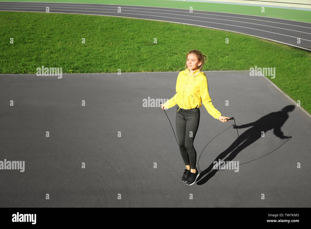 Sporty young woman jumping rope outdoors Stock Photo - Alamy
