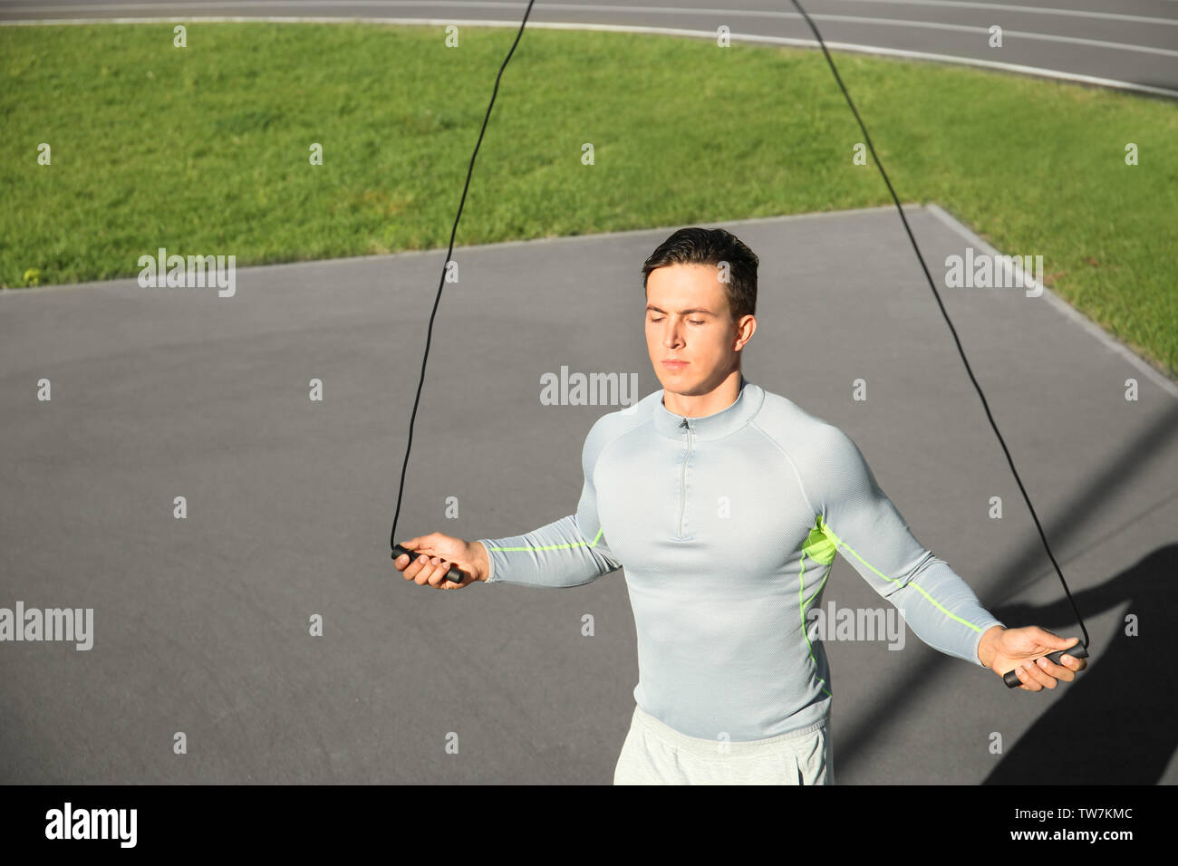 Sporty young man jumping rope outdoors Stock Photo - Alamy
