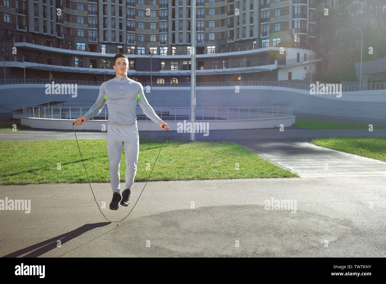 Sporty young man jumping rope outdoors Stock Photo - Alamy