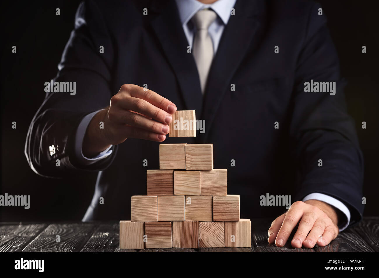 Man and wooden cubes on table. Management concept Stock Photo - Alamy