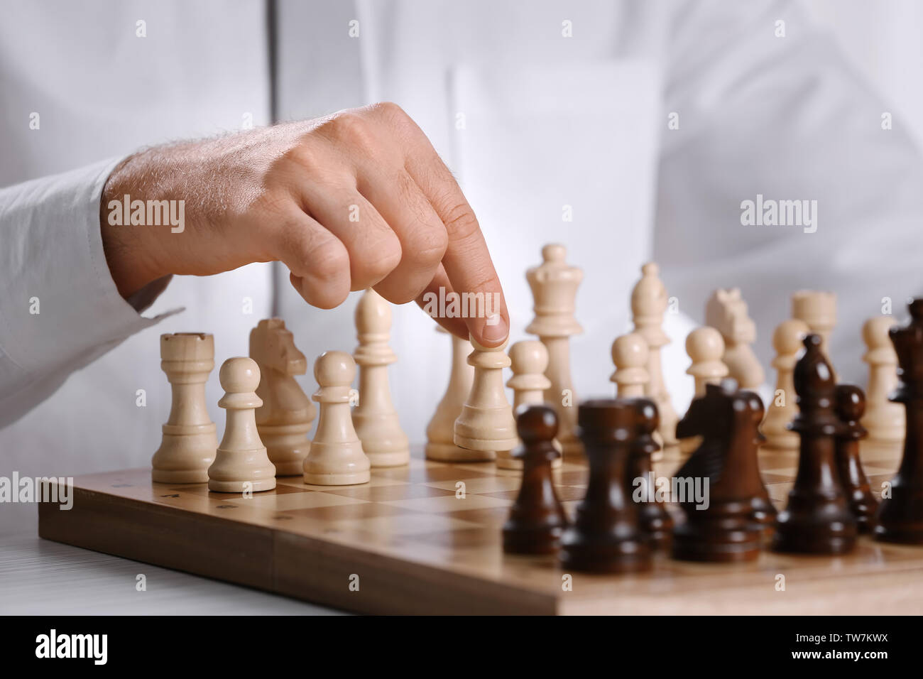 Man playing chess on table. Management concept Stock Photo - Alamy
