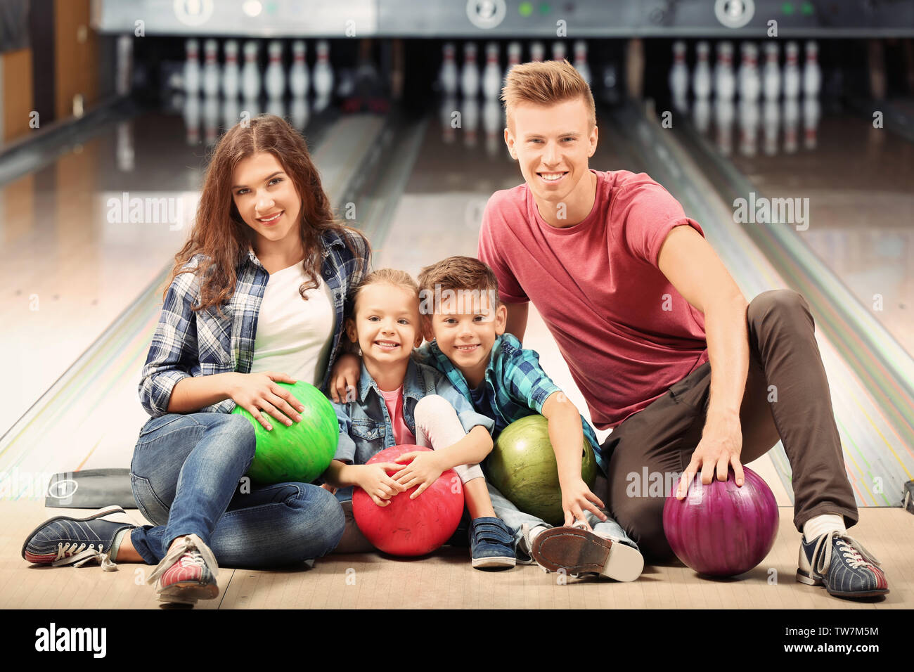 Family having fun in bowling club Stock Photo - Alamy