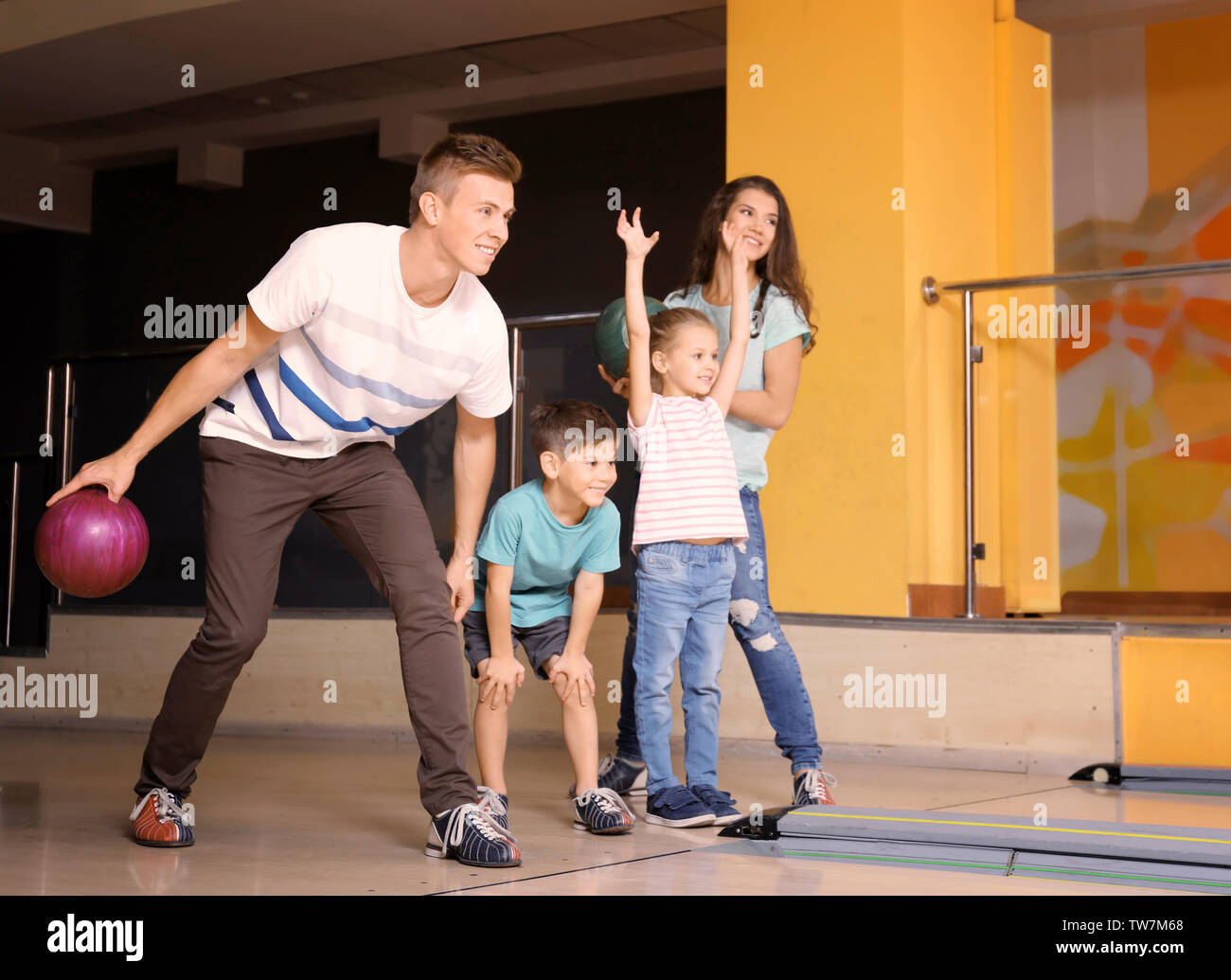 Family having fun in bowling club Stock Photo - Alamy