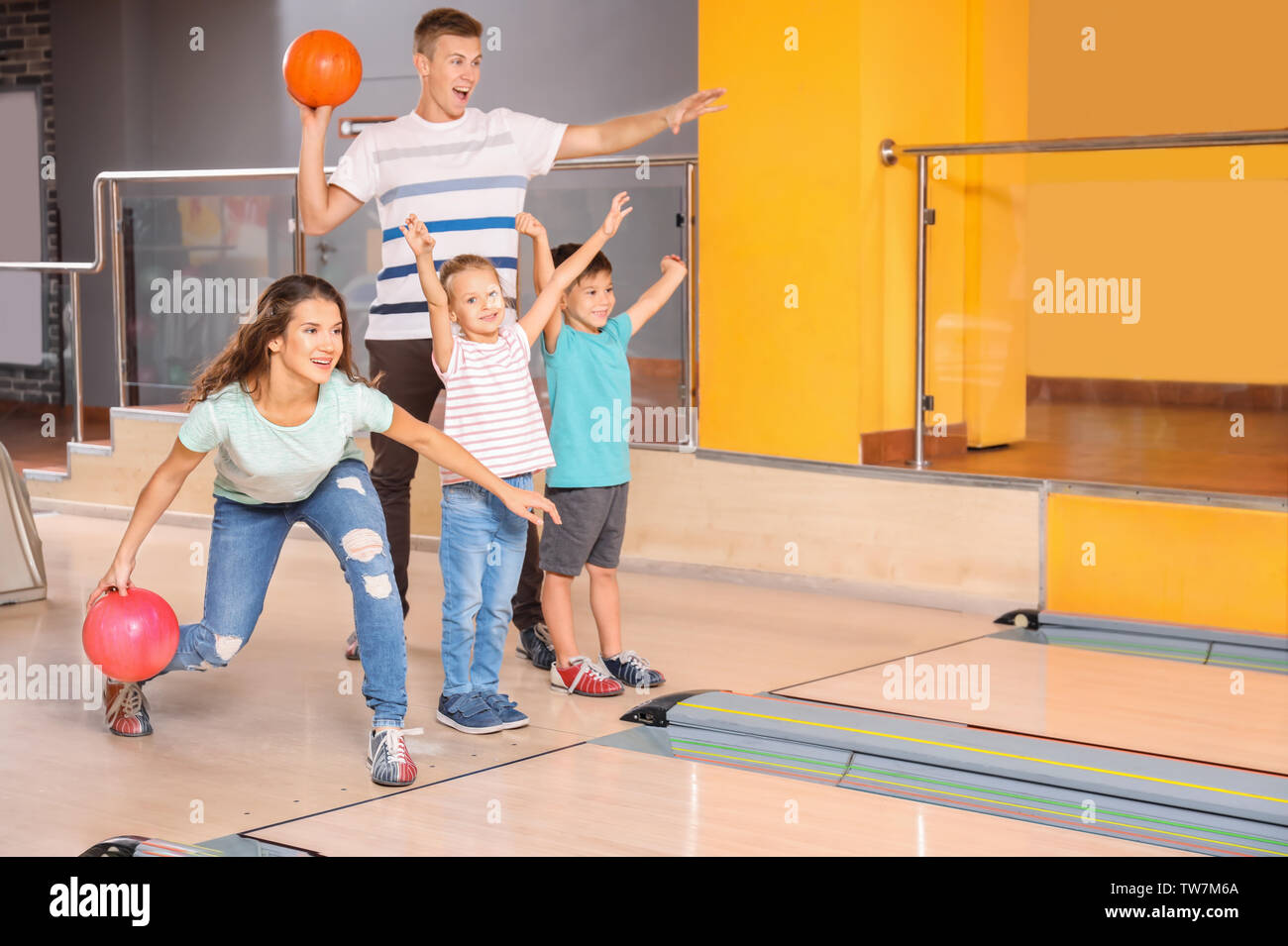 Family having fun in bowling club Stock Photo - Alamy