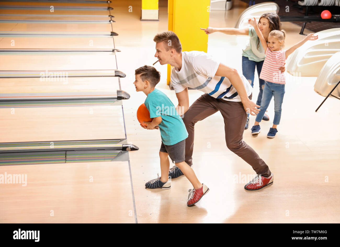 Family having fun in bowling club Stock Photo - Alamy
