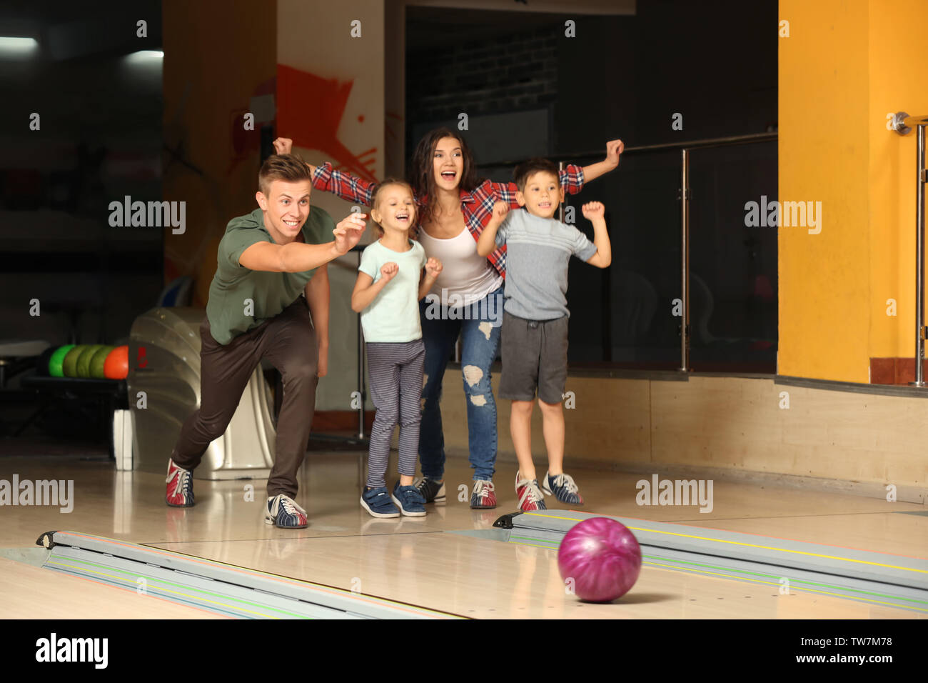 Family having fun in bowling club Stock Photo - Alamy