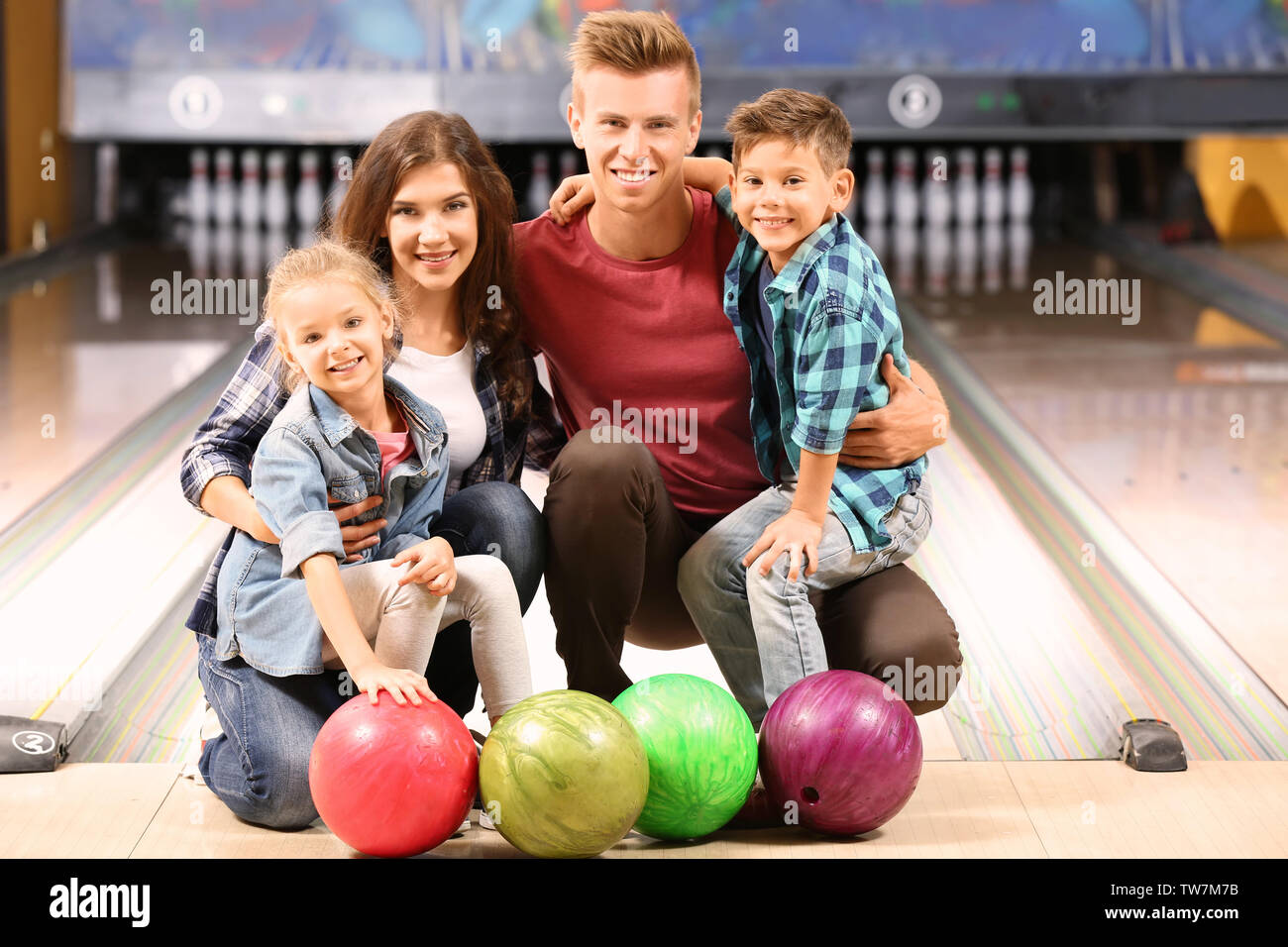 Family having fun in bowling club Stock Photo - Alamy