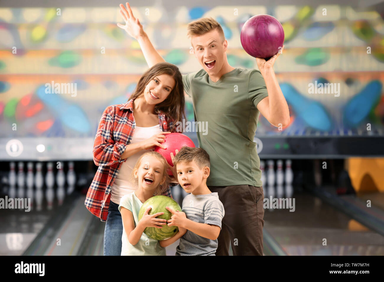 Family having fun in bowling club Stock Photo - Alamy