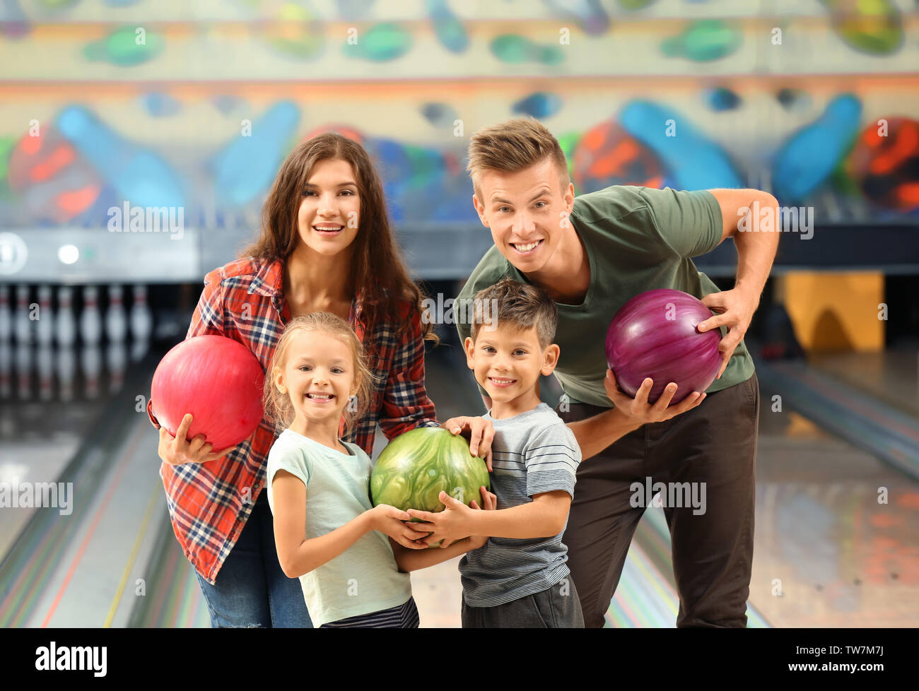 Family having fun in bowling club Stock Photo - Alamy