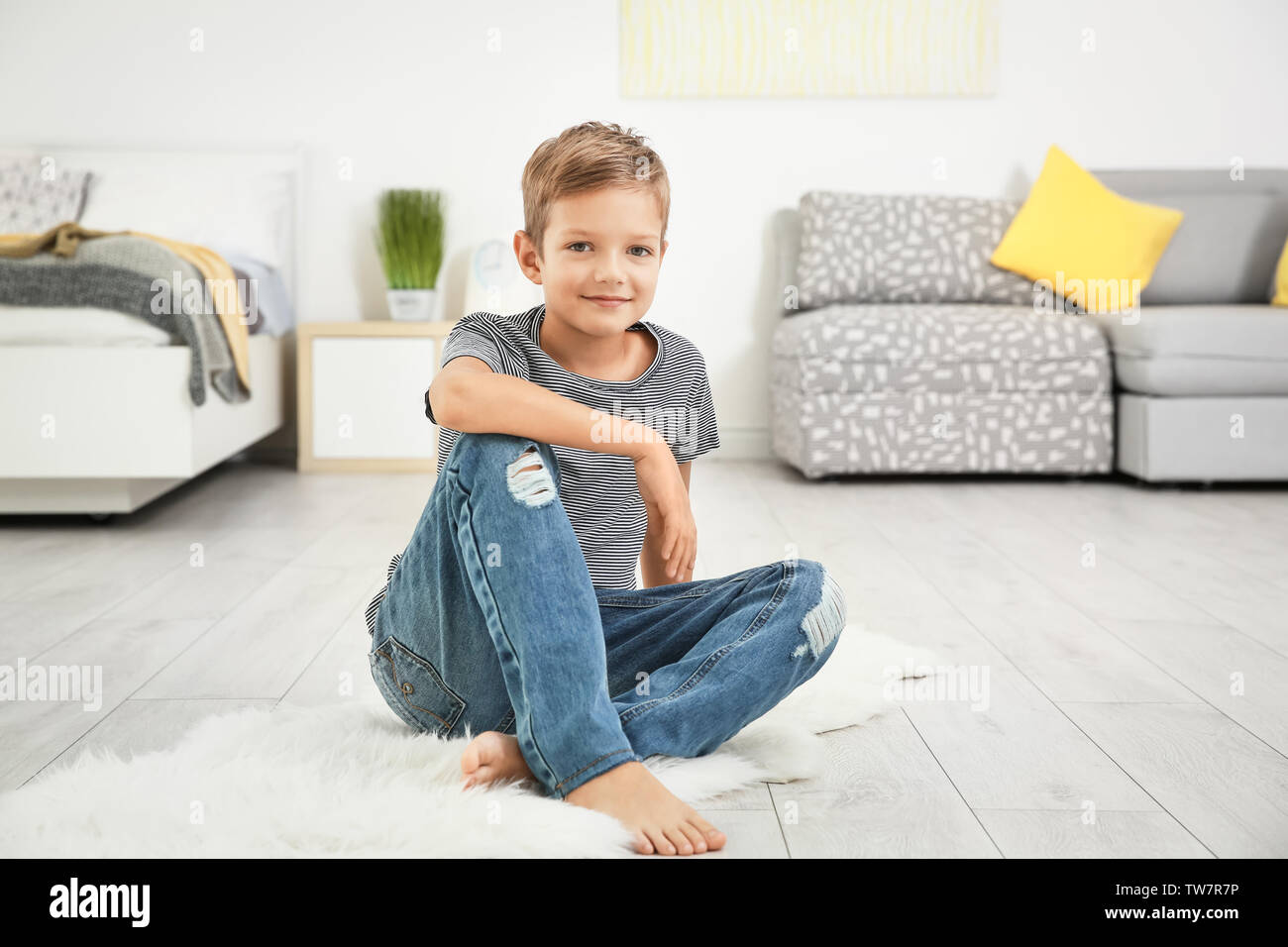 Cute little boy sitting on floor at home Stock Photo - Alamy