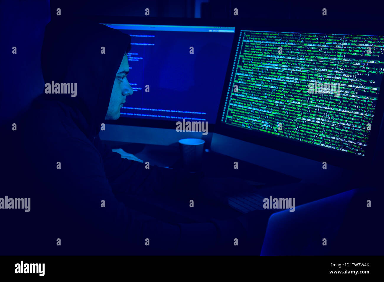 Hacker using computer in dark room Stock Photo - Alamy