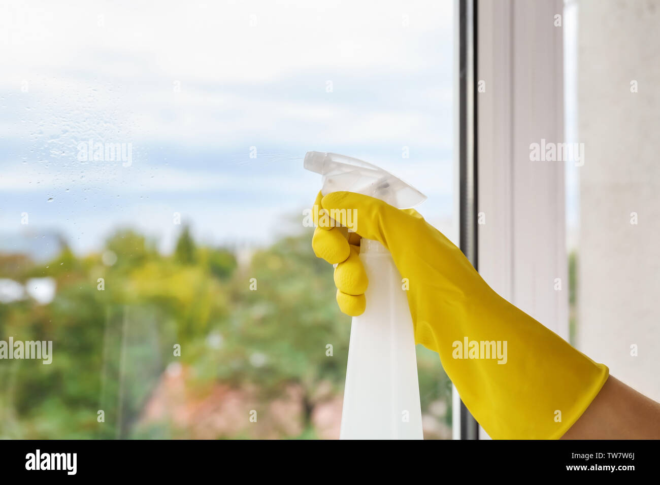 Cleaner washing window with spray detergent Stock Photo - Alamy