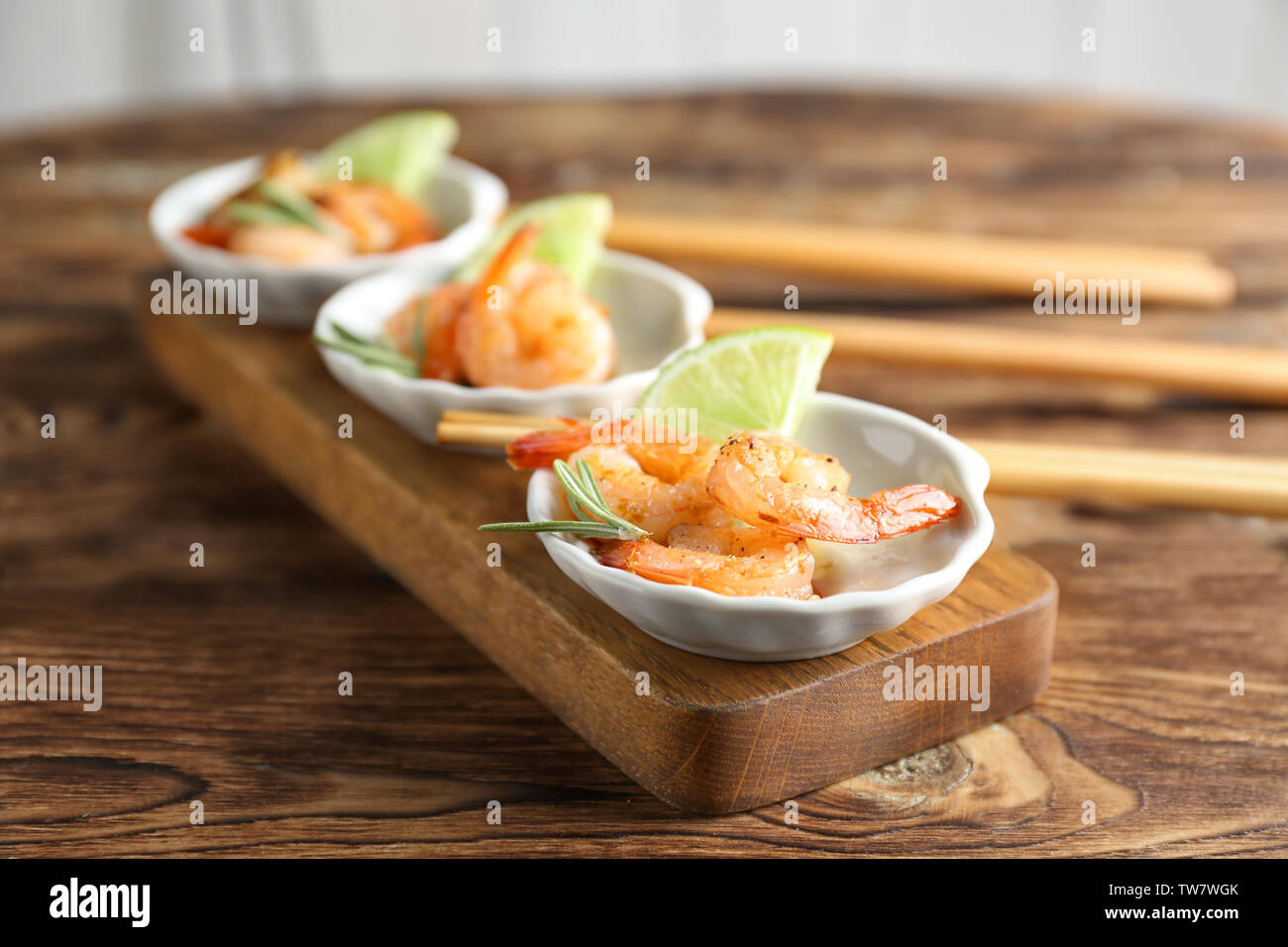 Plates with delicious grilled shrimps on wooden table Stock Photo - Alamy