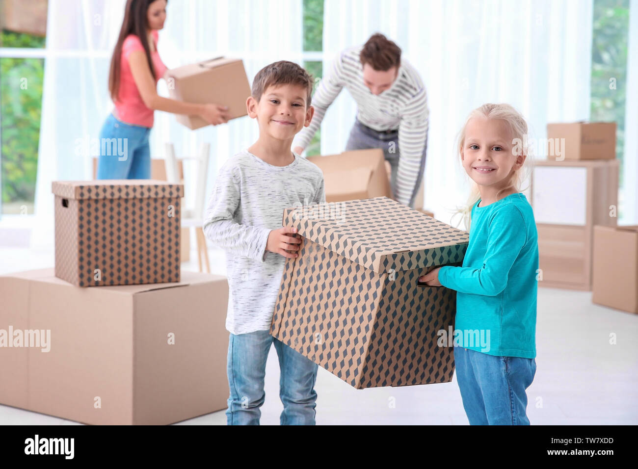 Happy siblings and parents in their new home Stock Photo - Alamy