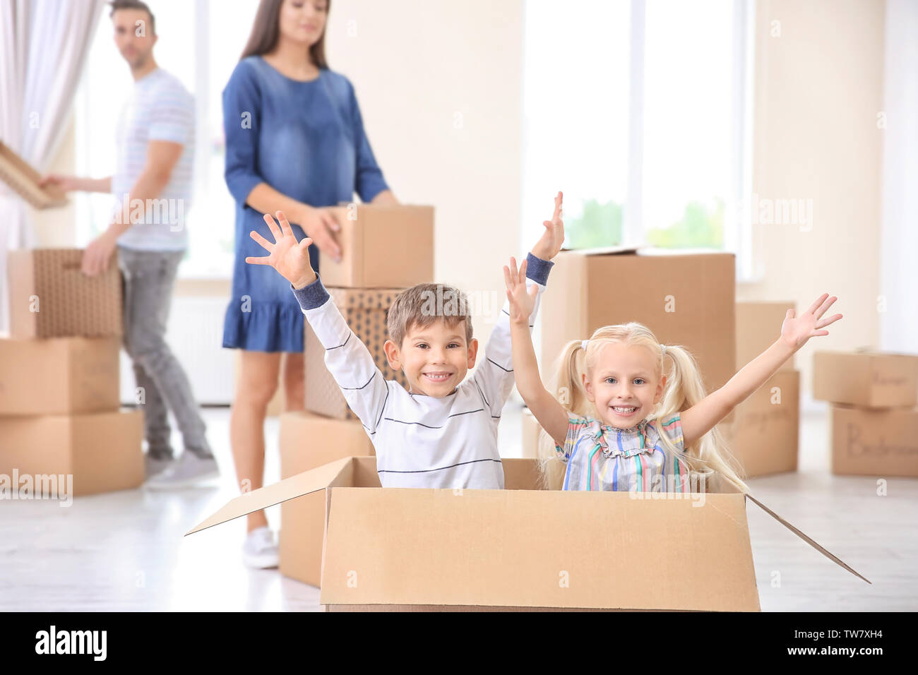 Happy siblings with parents having fun in their new home Stock Photo ...
