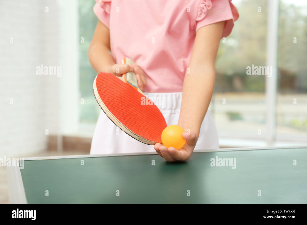 Cute little girl playing table tennis indoors Stock Photo - Alamy