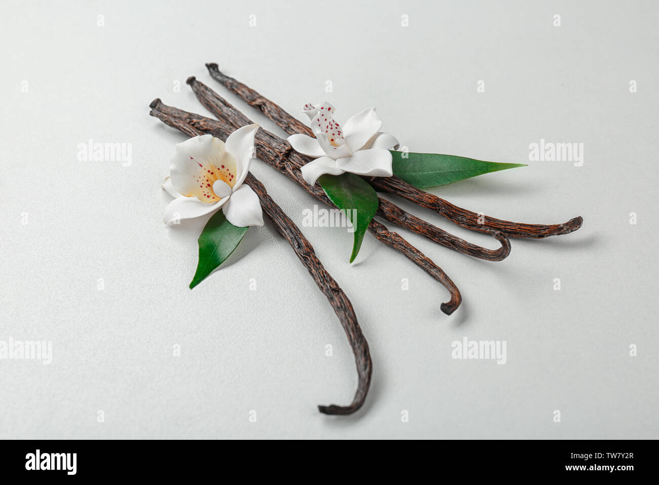 Dried vanilla pods and flowers on light background Stock Photo - Alamy