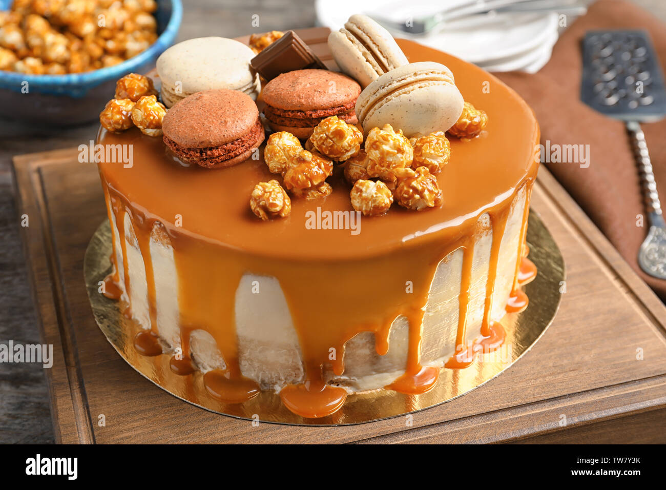 Board with delicious caramel cake on table Stock Photo - Alamy