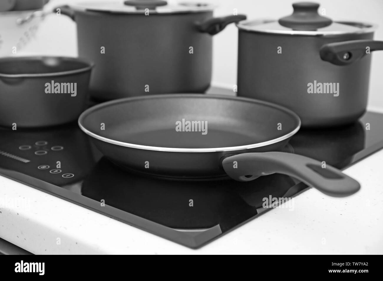 Cooking utensils on electric stove in kitchen Stock Photo - Alamy