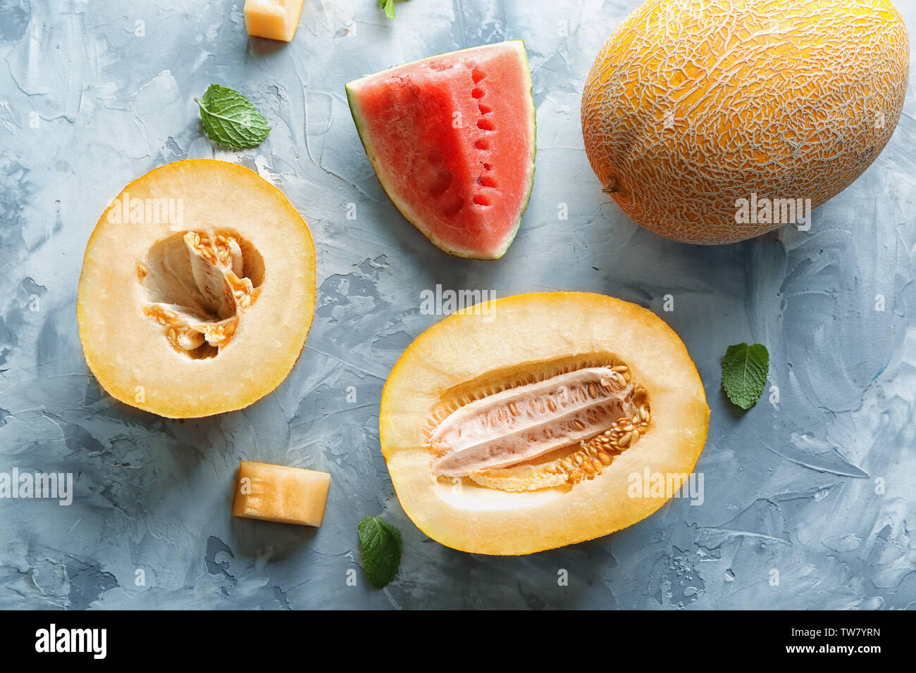 Yummy cut melon and watermelon on grey background, top view Stock Photo ...