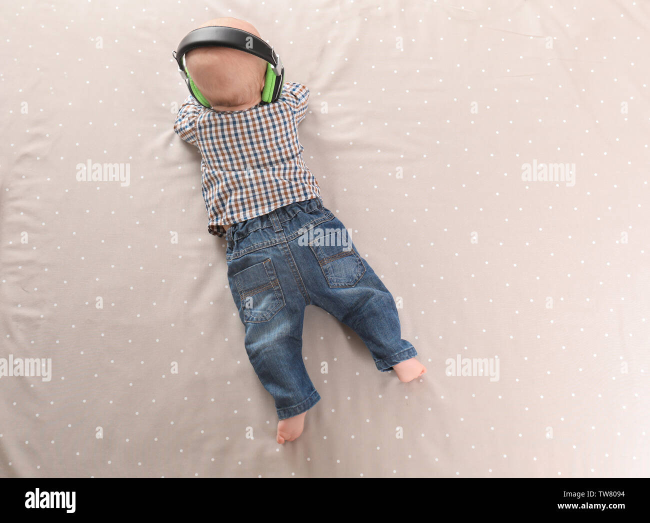 Cute baby listening to music on light background Stock Photo - Alamy