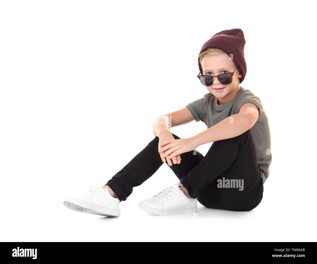 Cute fashionable boy sitting on white background Stock Photo - Alamy