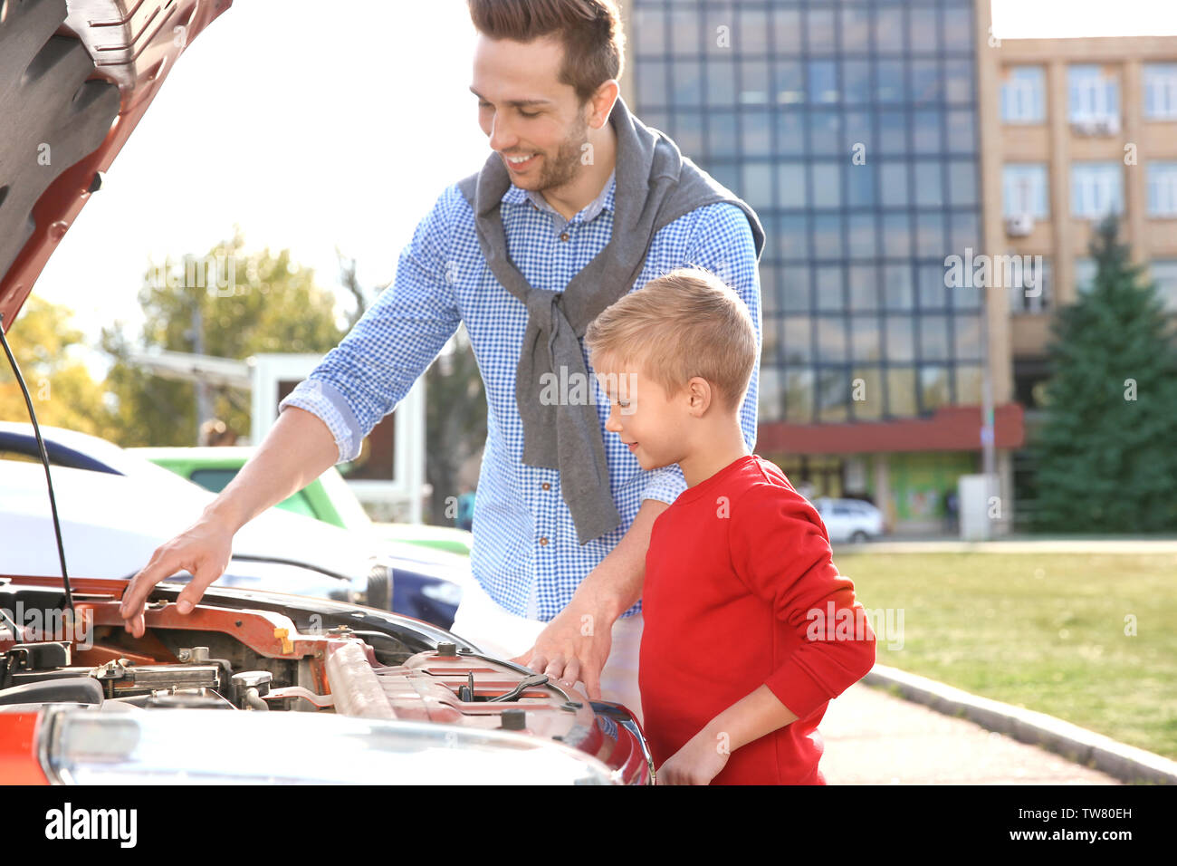 Young father with cute boy repairing car, outdoors Stock Photo - Alamy