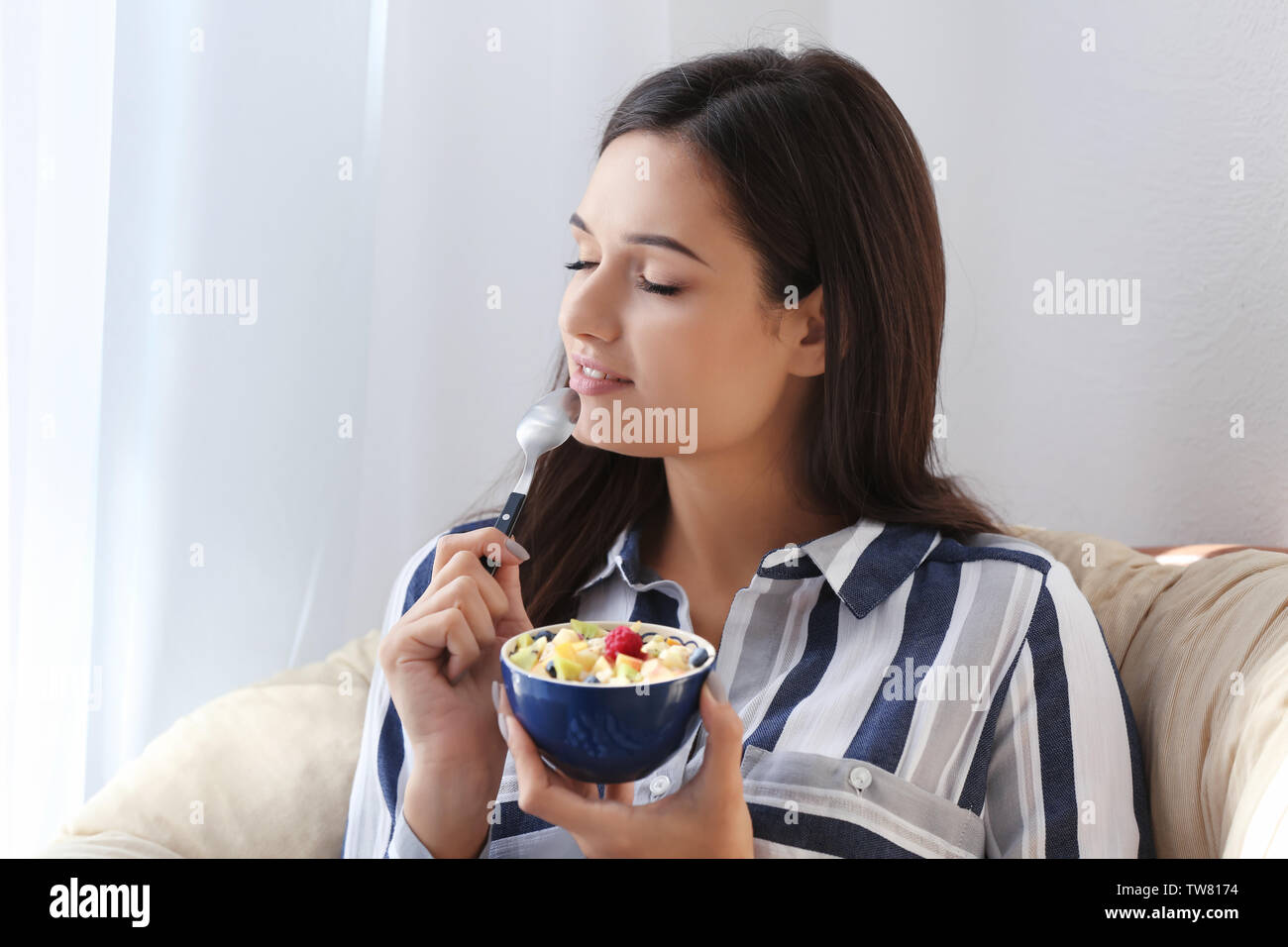 Young woman eating oatmeal porridge hi-res stock photography and images ...