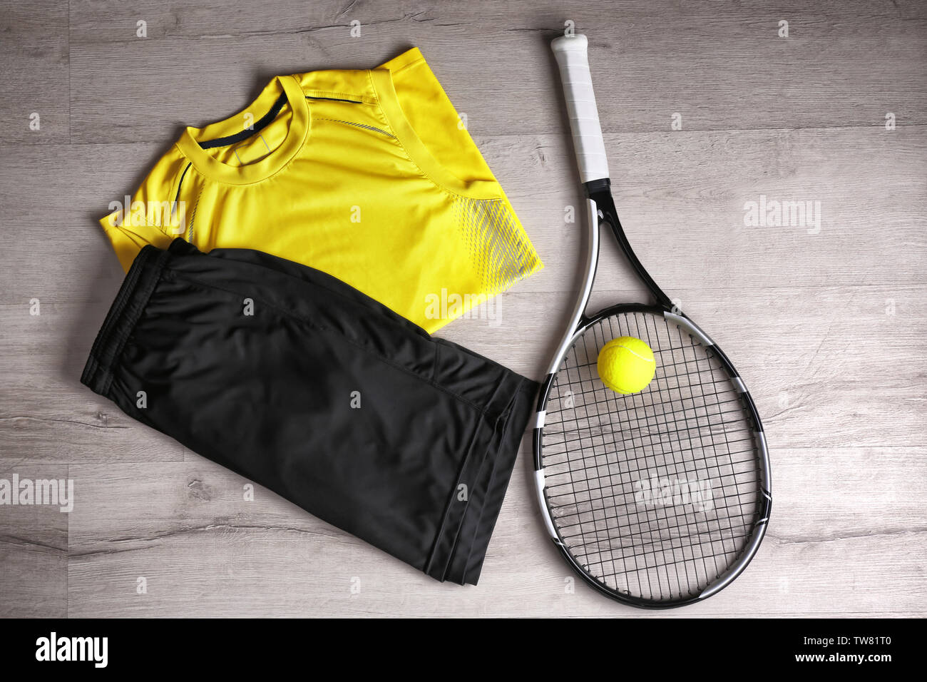 Tennis racket, ball, clothes and shoes on wooden background Stock Photo ...
