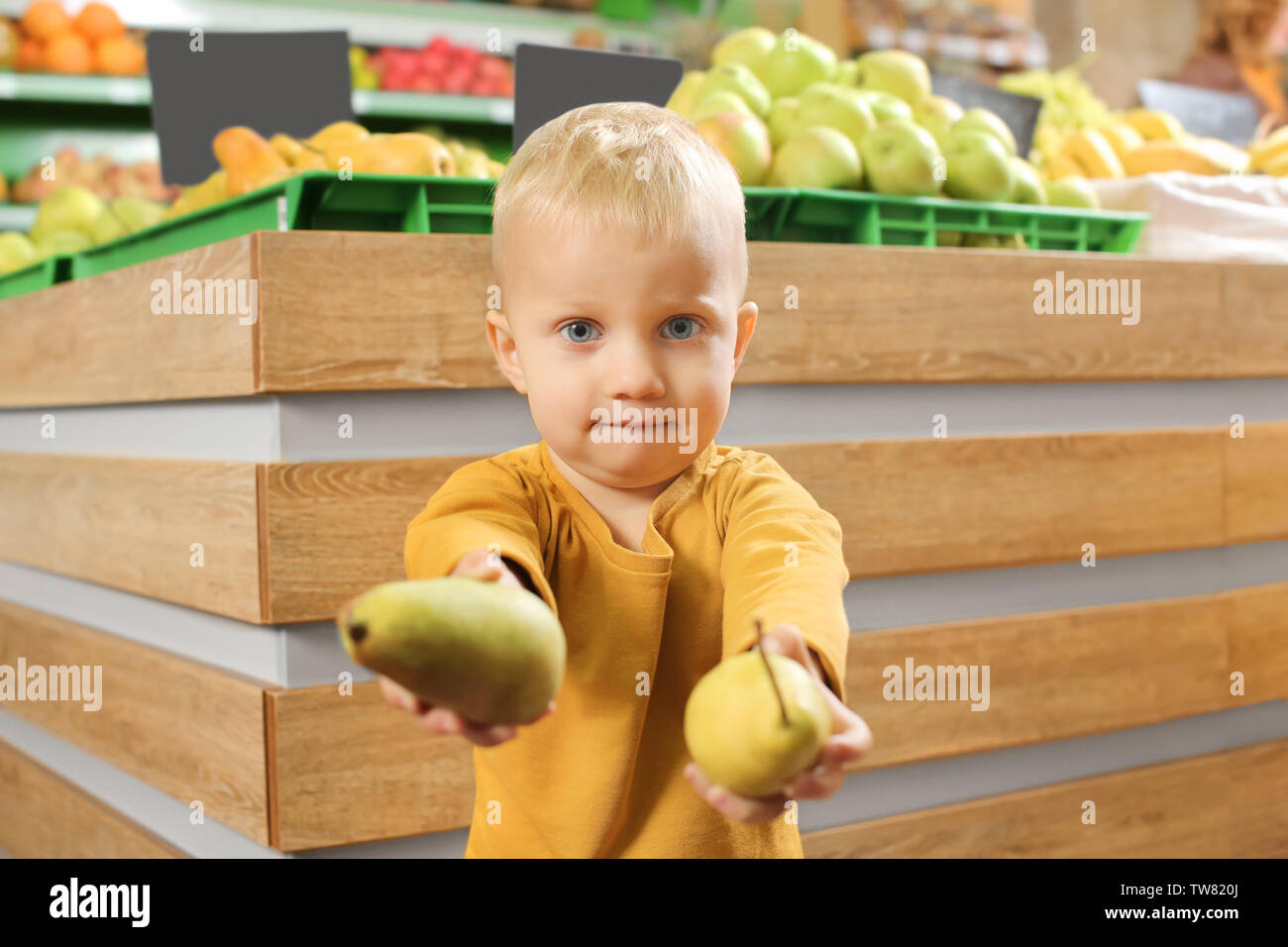 Cute little boy choosing pears in supermarket Stock Photo - Alamy