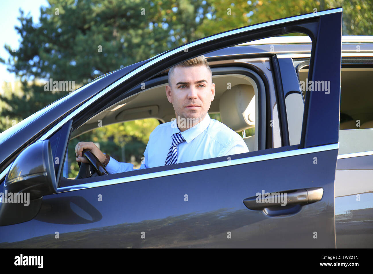 Man in formal wear getting out of car Stock Photo - Alamy