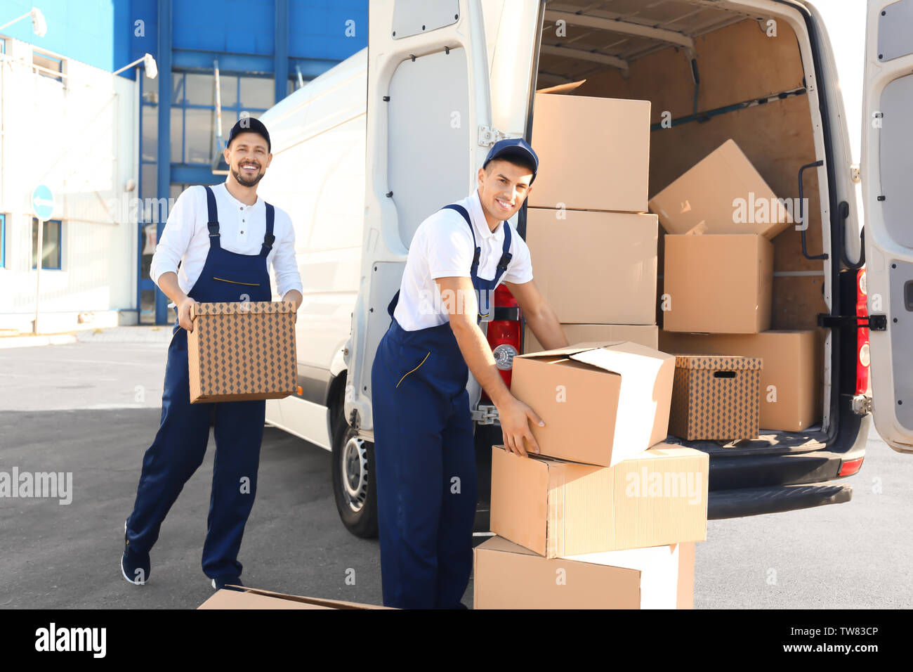Delivery men unloading moving boxes from car Stock Photo - Alamy