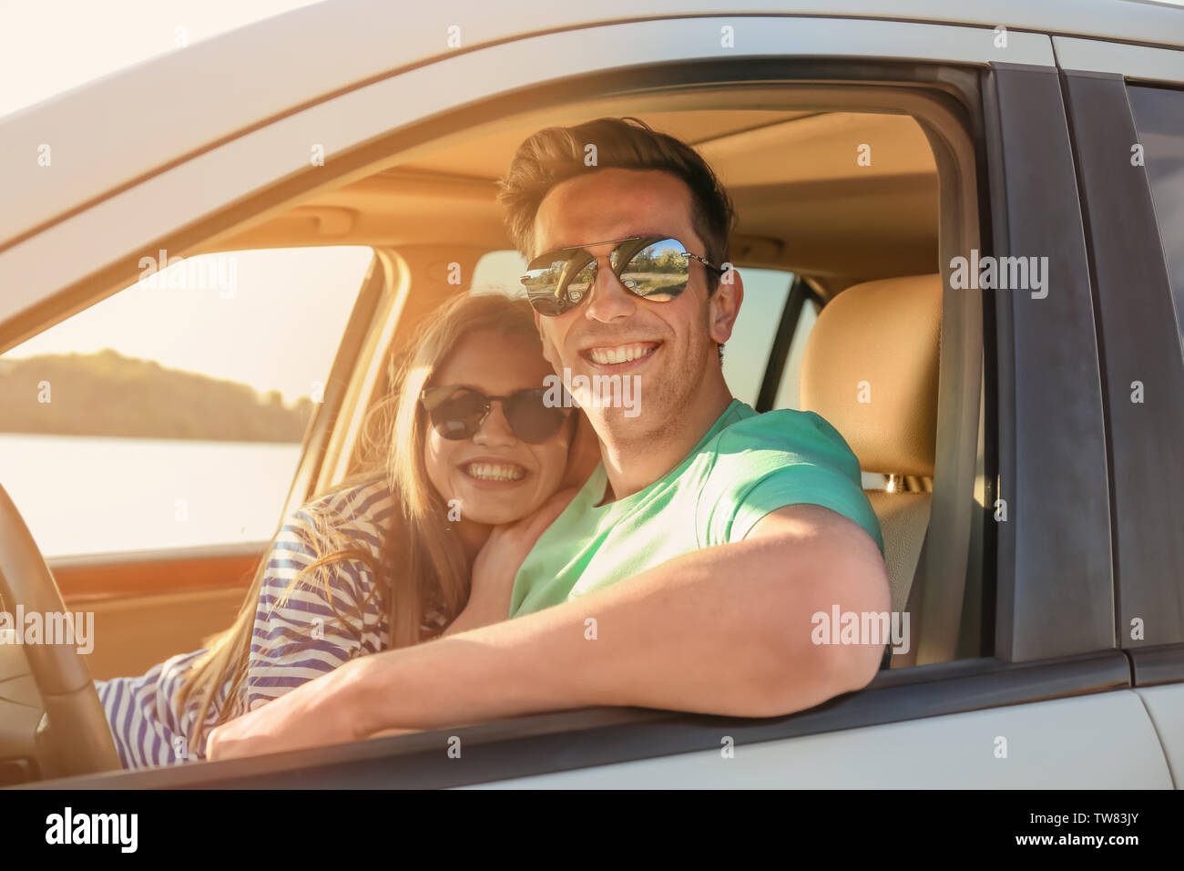 Beautiful young couple in car Stock Photo - Alamy