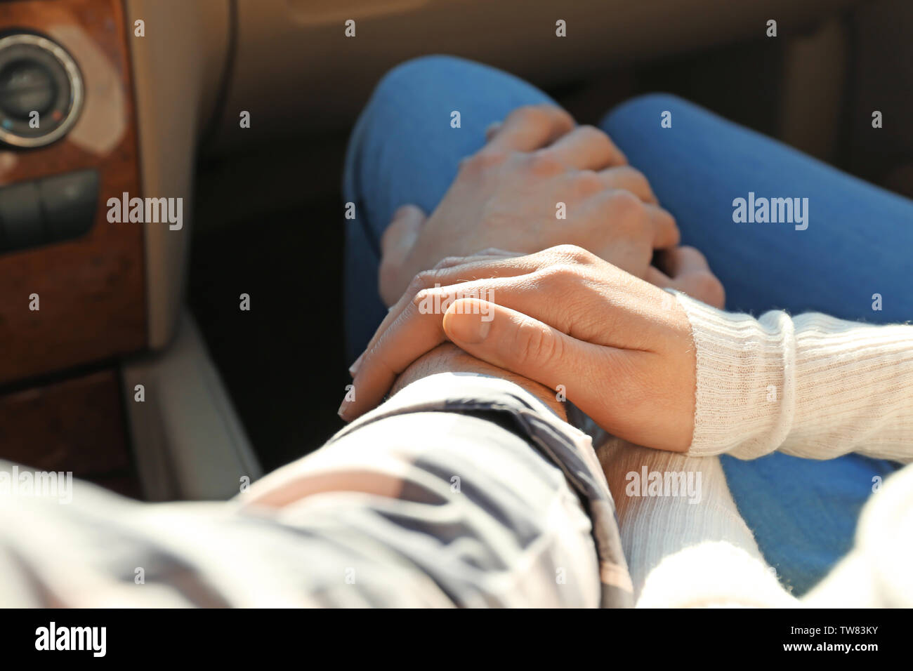 Young couple holding hands together in car Stock Photo - Alamy