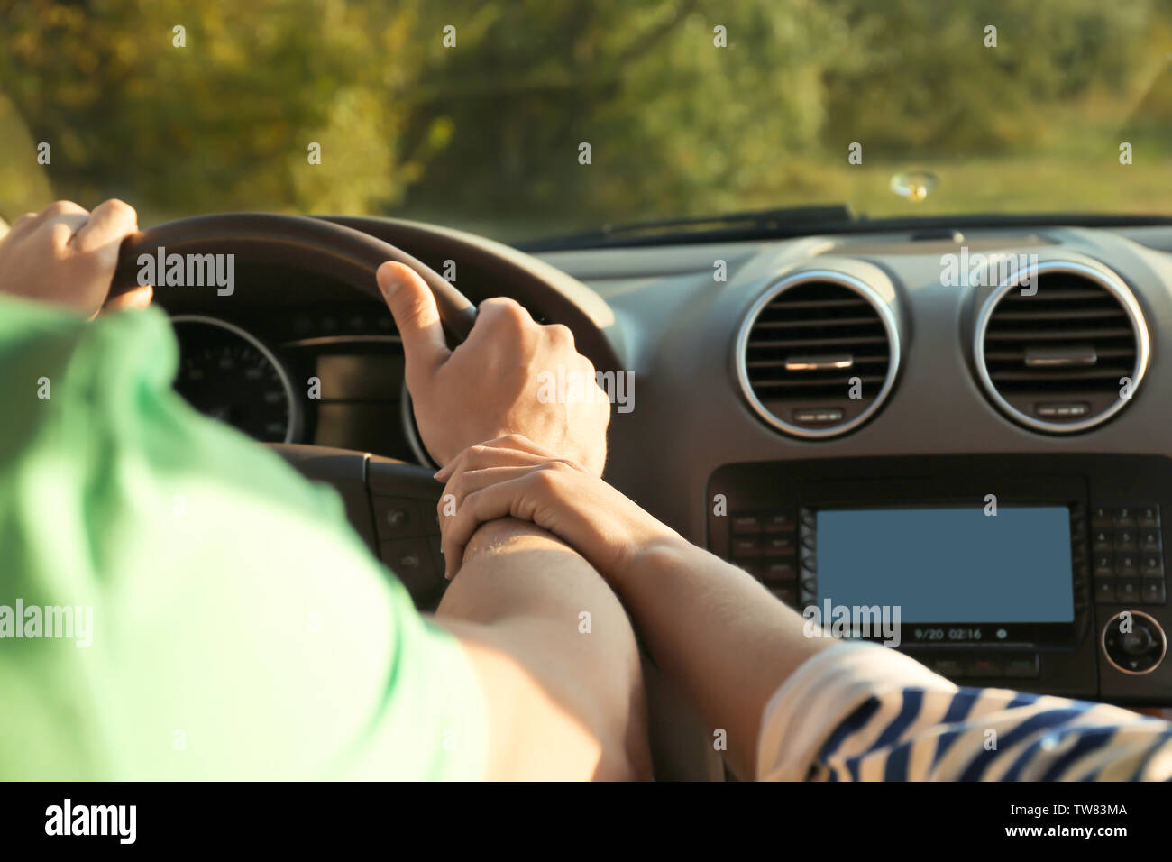 Young couple holding hands together in car Stock Photo - Alamy