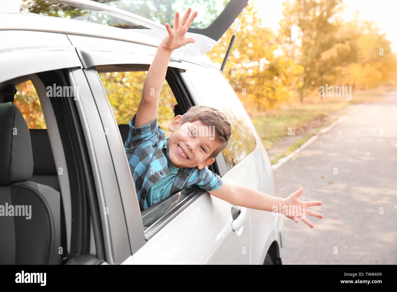 Adorable little boy leaning out of car window Stock Photo - Alamy