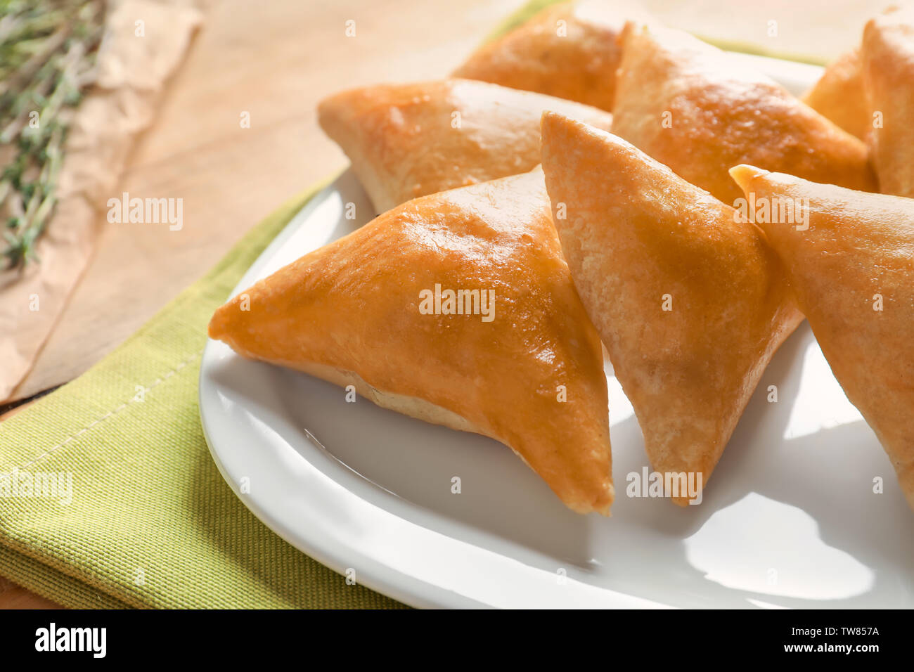 Plate with delicious baked samosas on table, closeup Stock Photo - Alamy