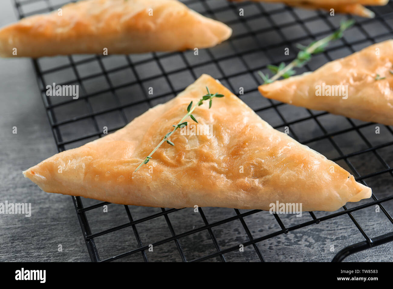 Cooling rack with delicious samosas on table, closeup Stock Photo - Alamy