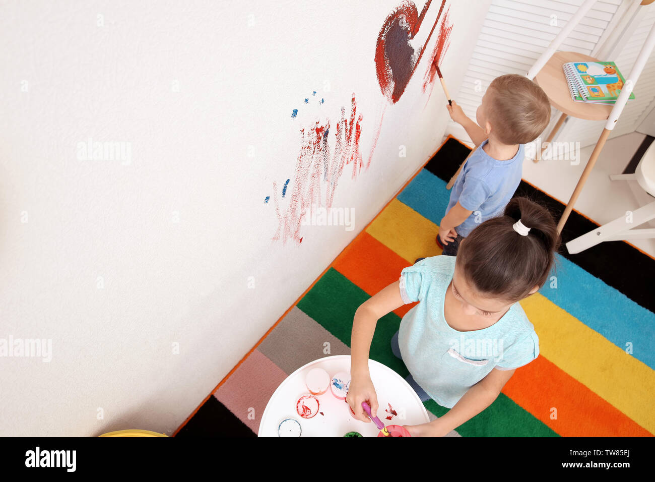 Little children painting on wall at home Stock Photo - Alamy