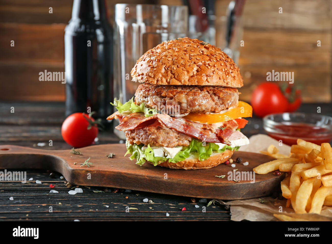 Board with tasty double burger on wooden table Stock Photo - Alamy