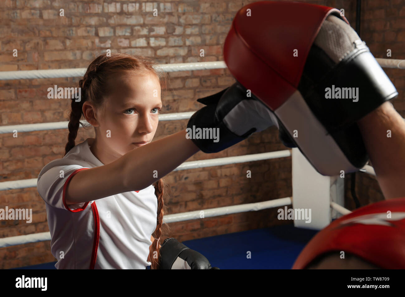Little girl with trainer on boxing ring Stock Photo - Alamy