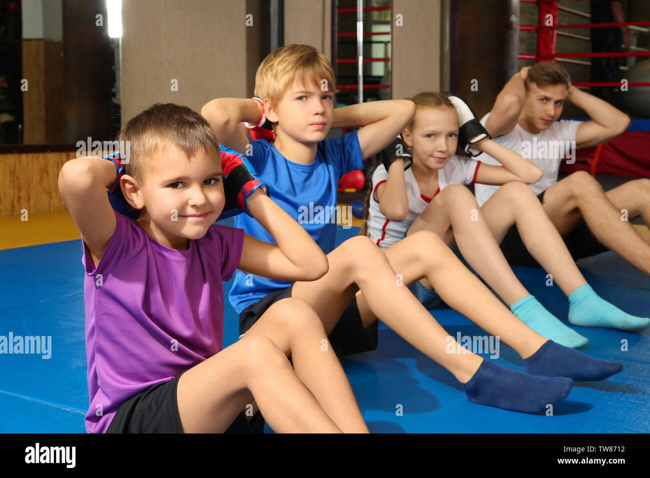 Little children doing exercises with trainer in gym Stock Photo - Alamy